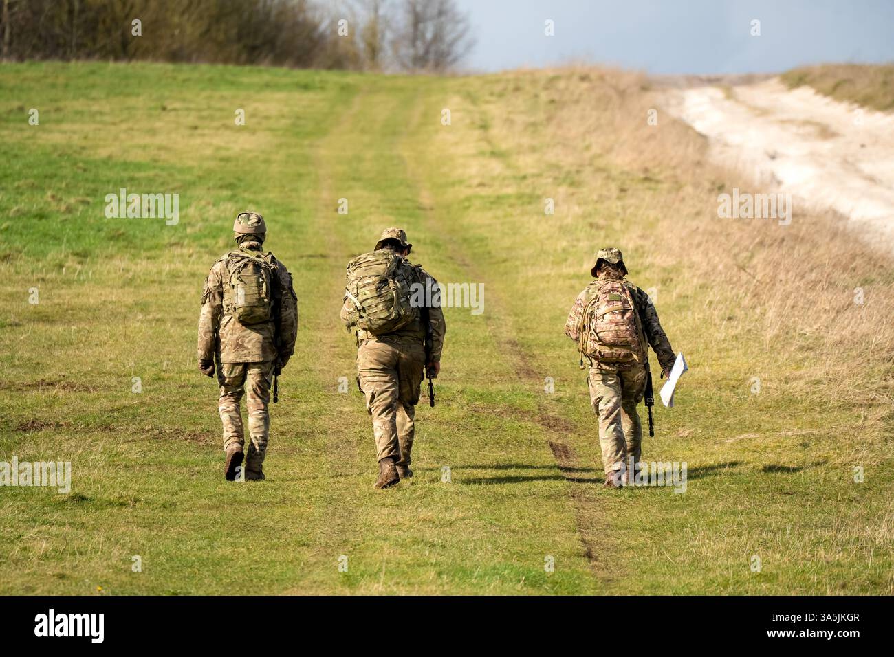 2 male and 1 female British army infantry soldiers tabbing with 25Kg ...