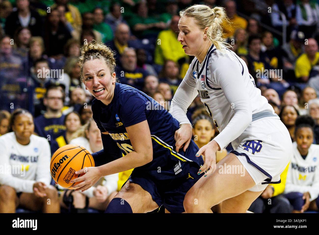 Michigan guard Jordan Hobbs, left, drives around Notre Dame forward ...