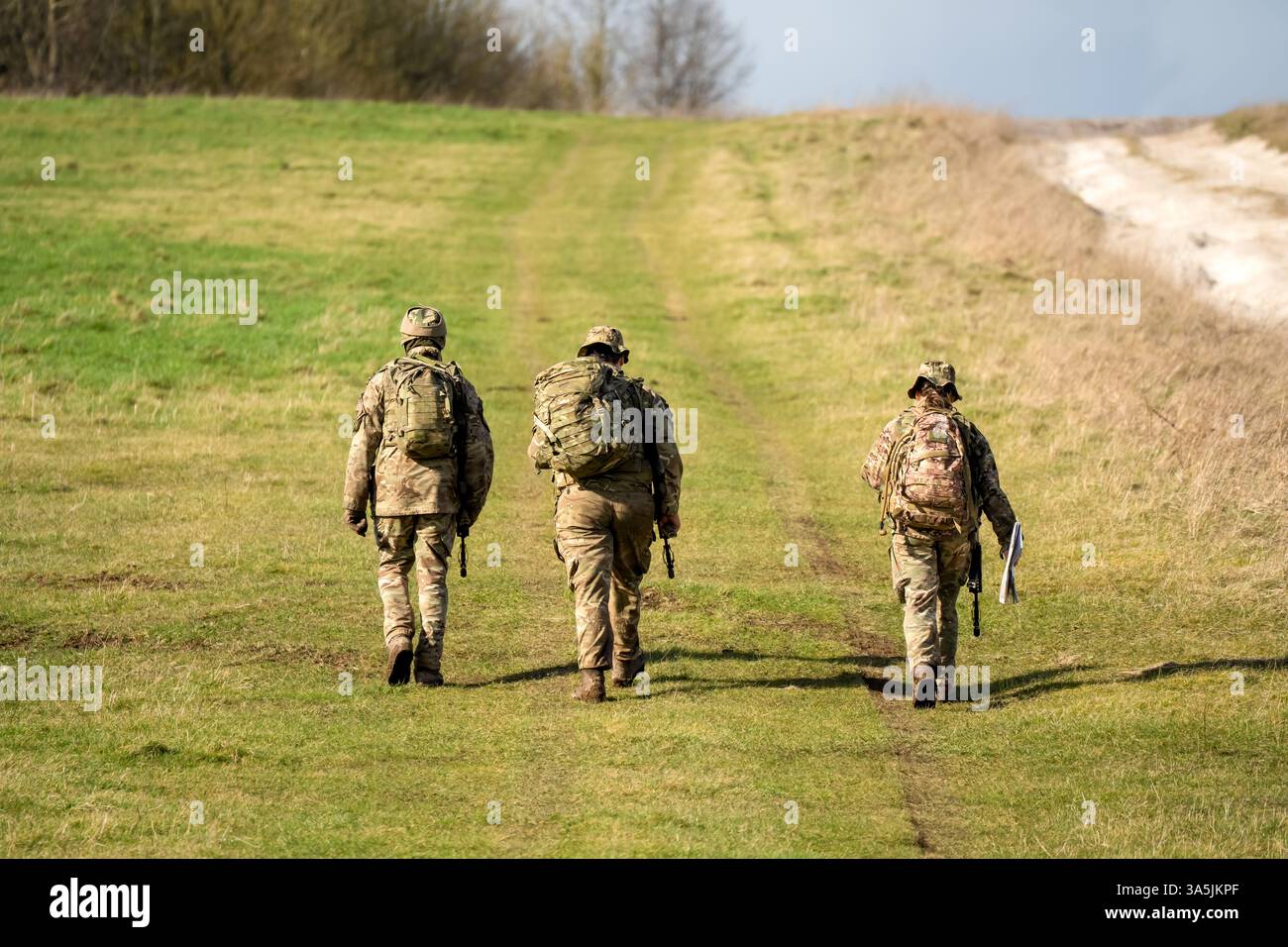 2 male and 1 female British army infantry soldiers tabbing with 25Kg ...