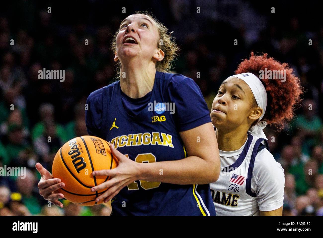 Michigan guard Jordan Hobbs, left, goes up to shoot as Notre Dame guard ...