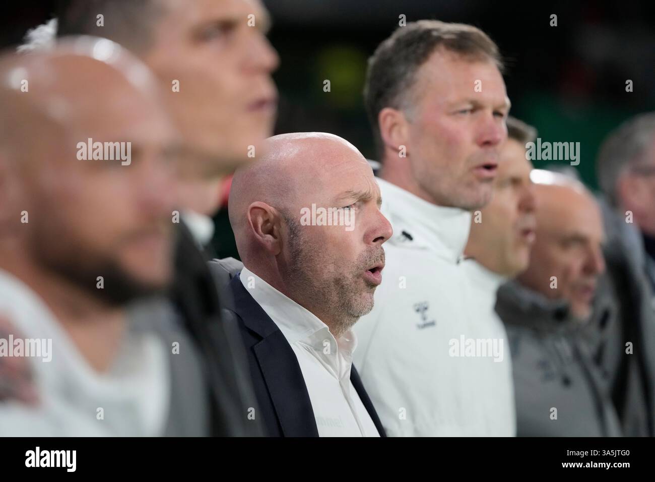Denmark coach Brian Riemer, center, sings the national anthem before ...