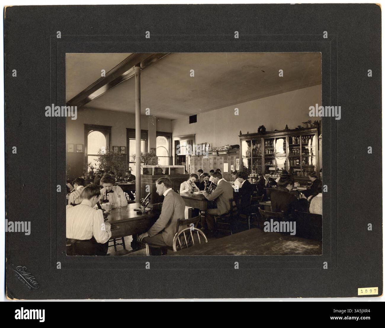 This image depicts students using microscopes in the biological ...