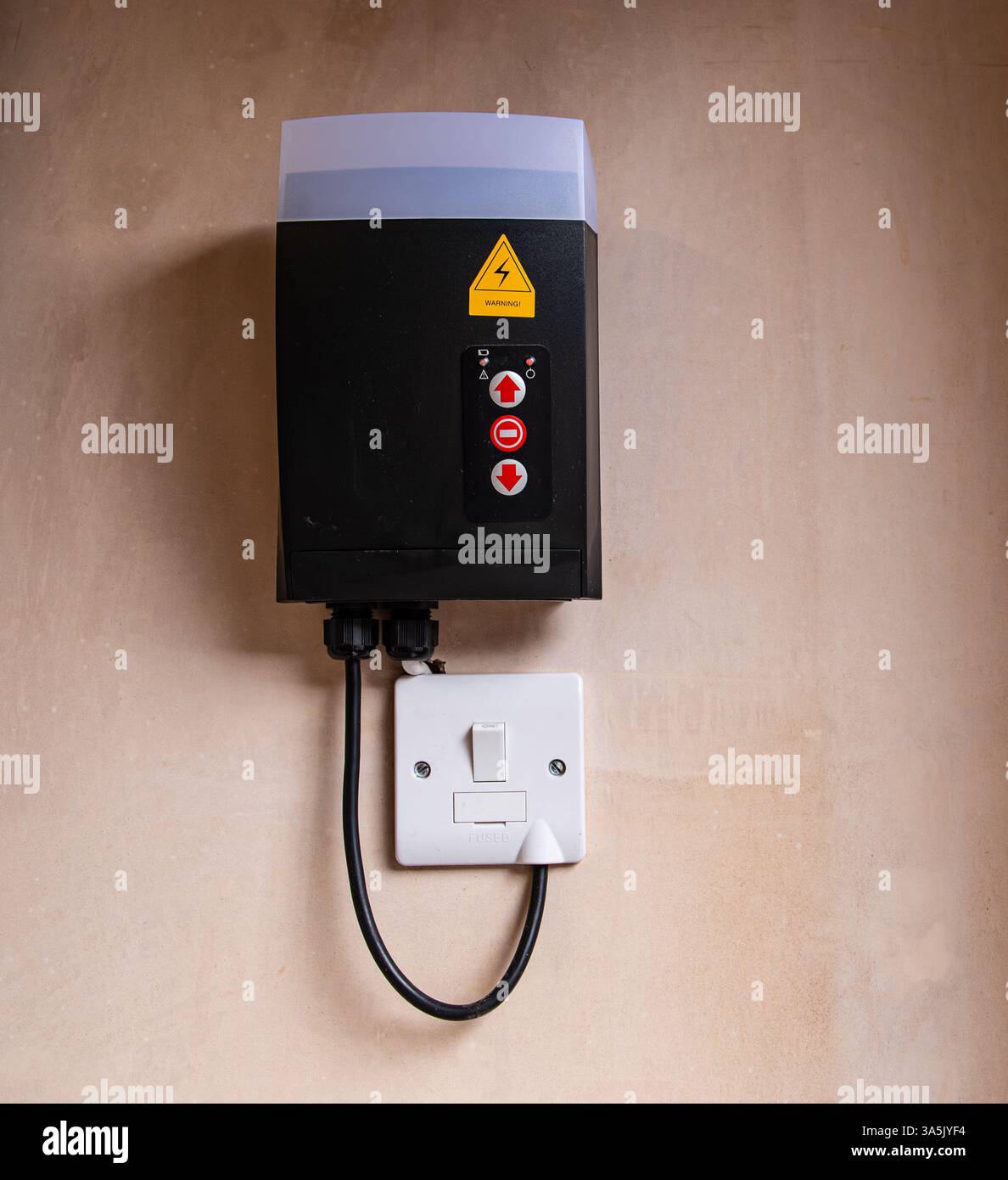 Black electrical garage door control buttons and warning sign mounted ...