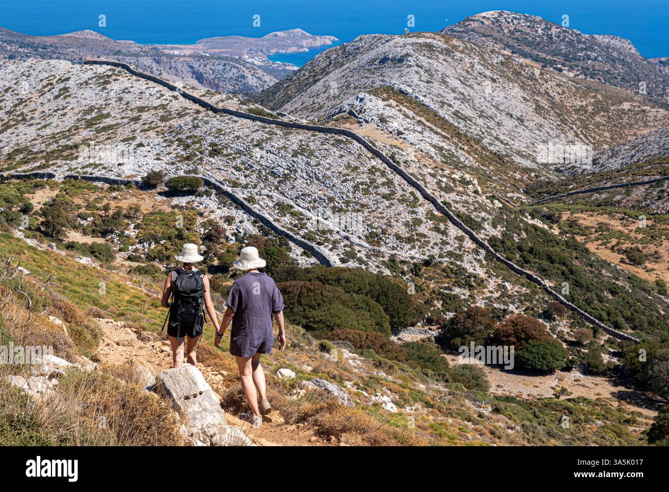 Naxos, Greece - 2 October 2024: Two hikers walking down a trail on ...