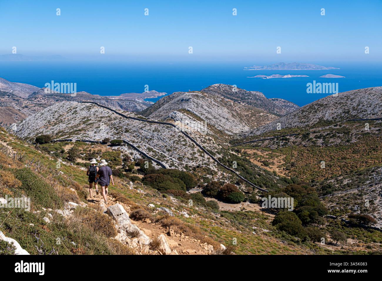 Naxos, Greece - 2 October 2024: Two hikers walking down a trail on ...