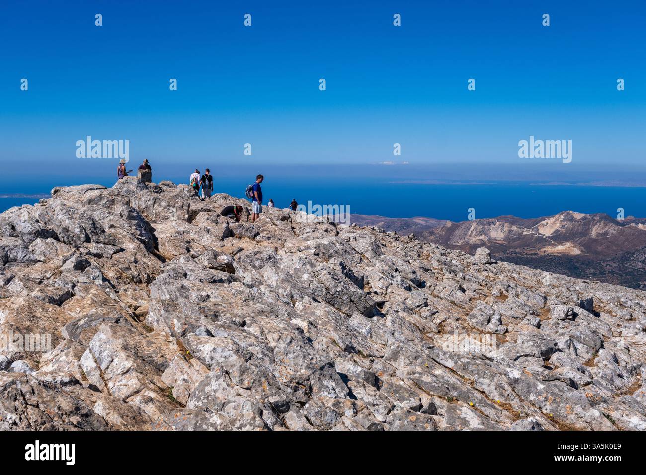 Naxos, Greece - 2 October 2024: Hikers standing atop rocky Mount Zeus ...
