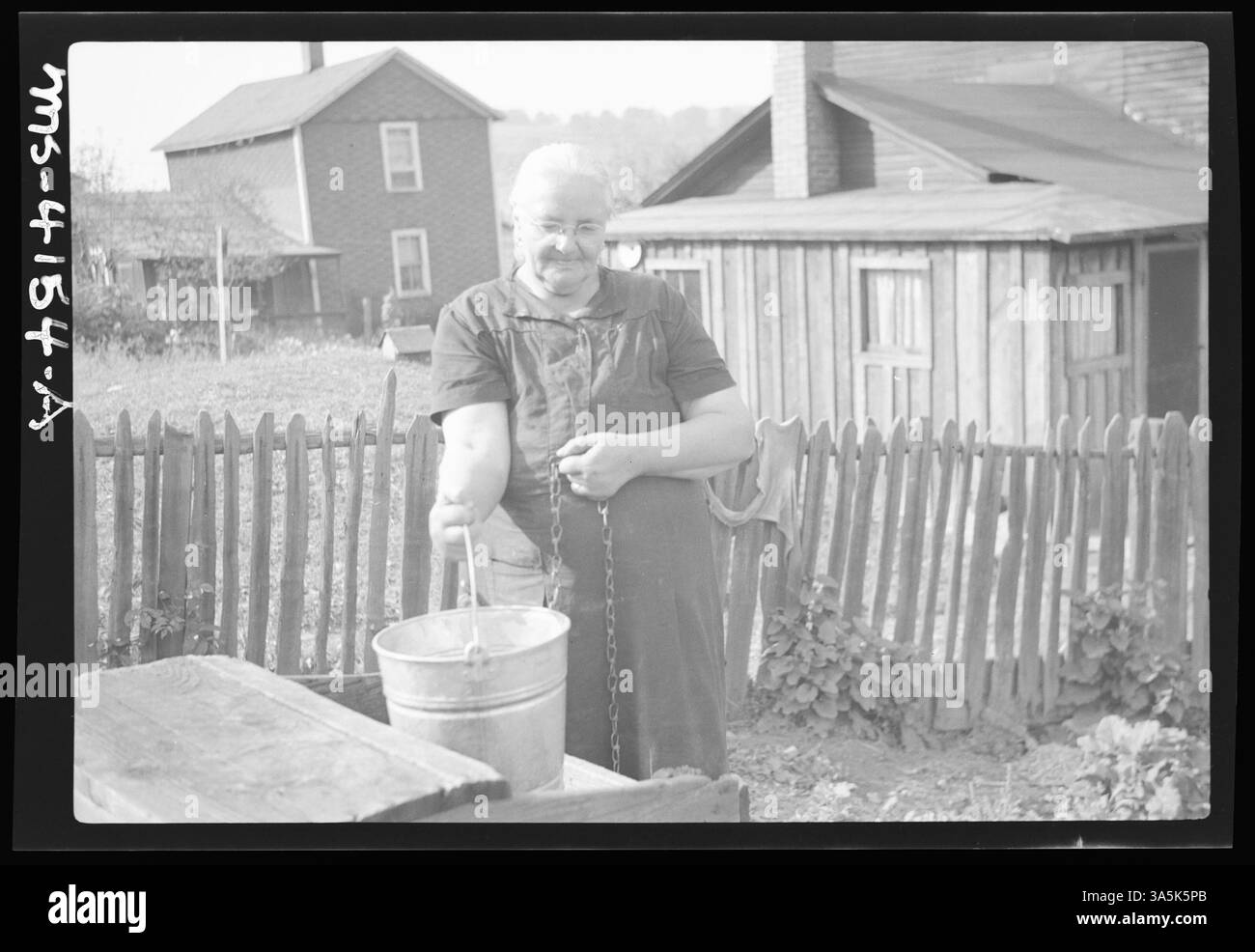 A photograph of workers baling drinking water from a surface well near ...