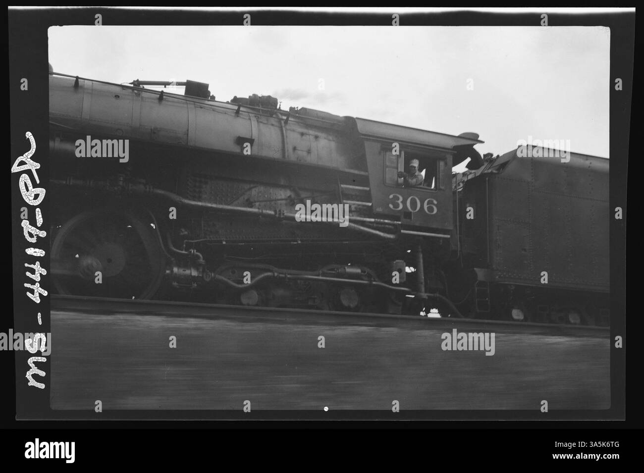 This 1946 image captures a moving train with the conductor visible ...