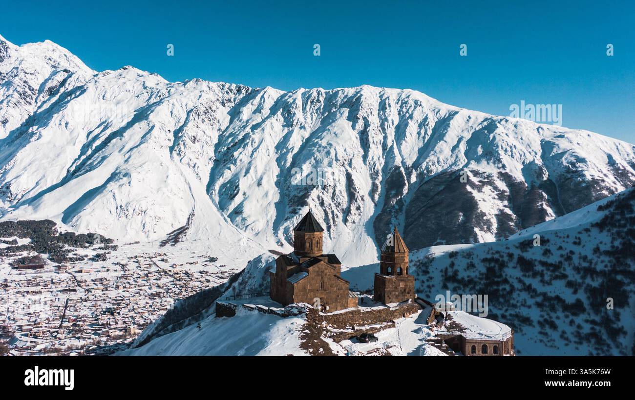 Gergeti trinity church sits on a hilltop overlooking the town of ...