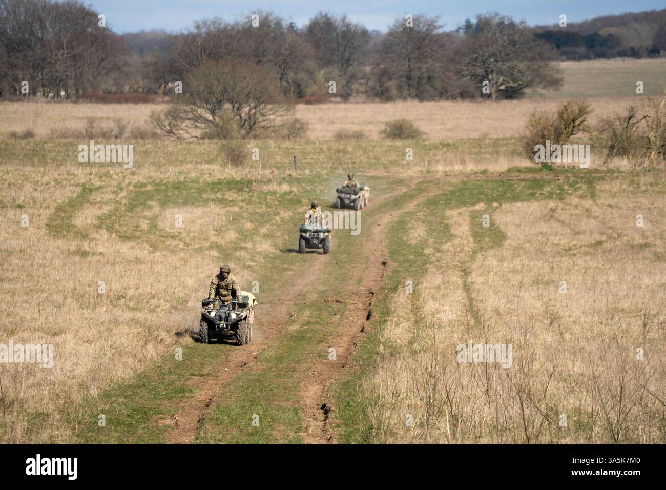 convoy of British army soldiers driving an all-terrain quad bikes with ...