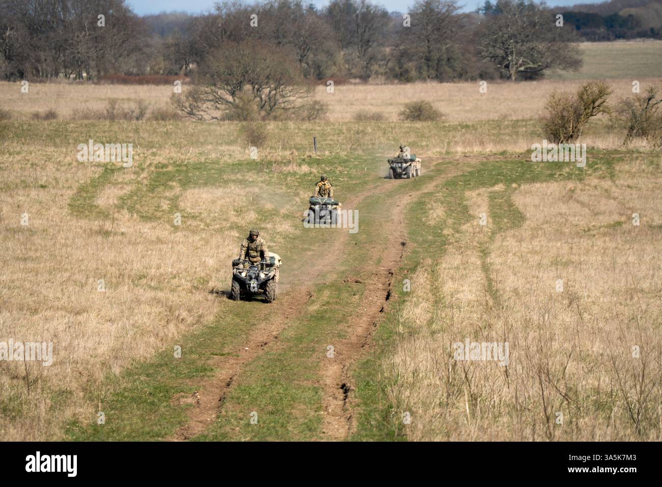 convoy of British army soldiers driving an all-terrain quad bikes with ...