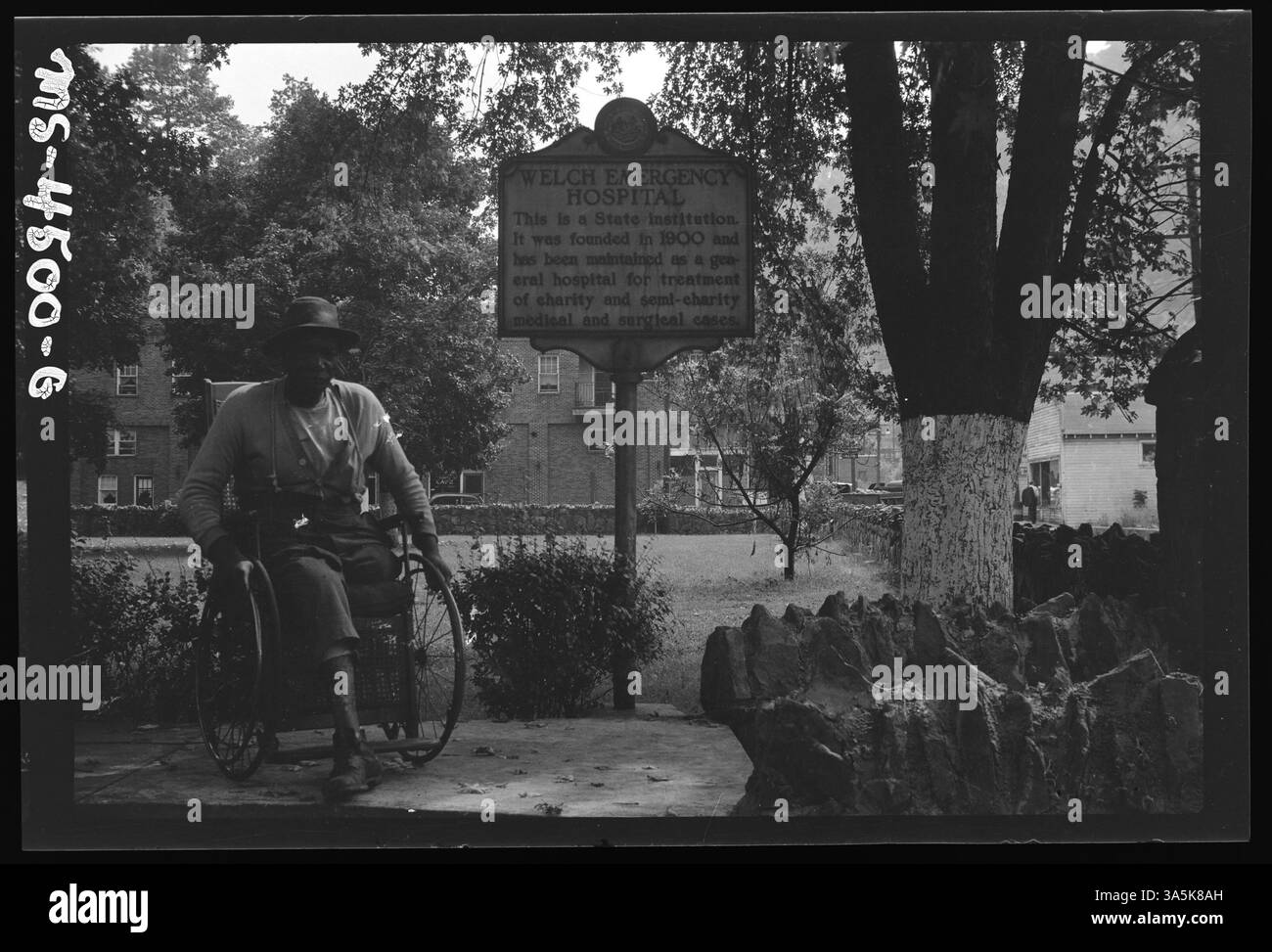 A man in a wheelchair is pictured beside the landmark sign for Welch ...