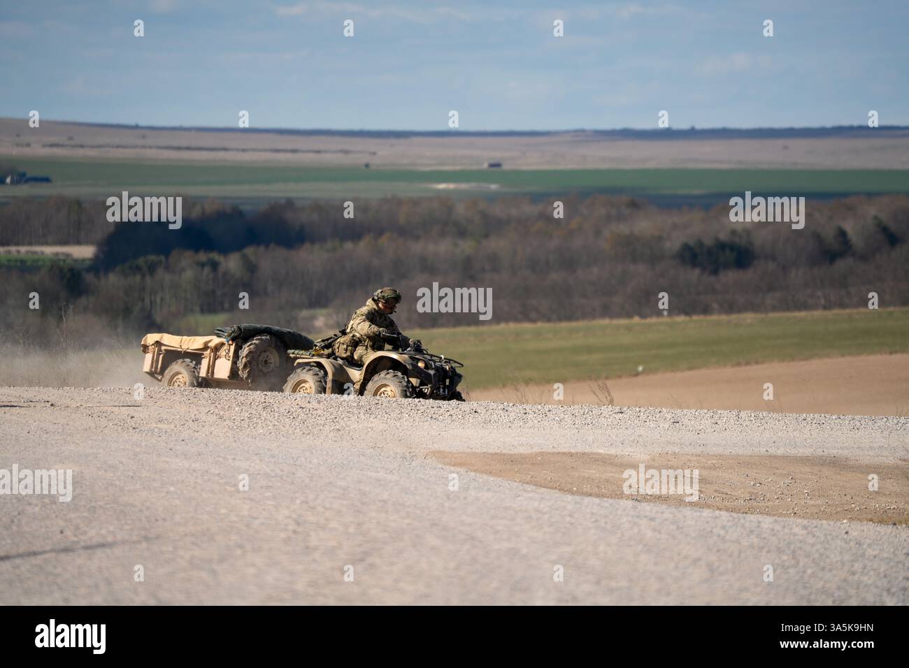British army soldier driving an all-terrain quad bike with trailer ...