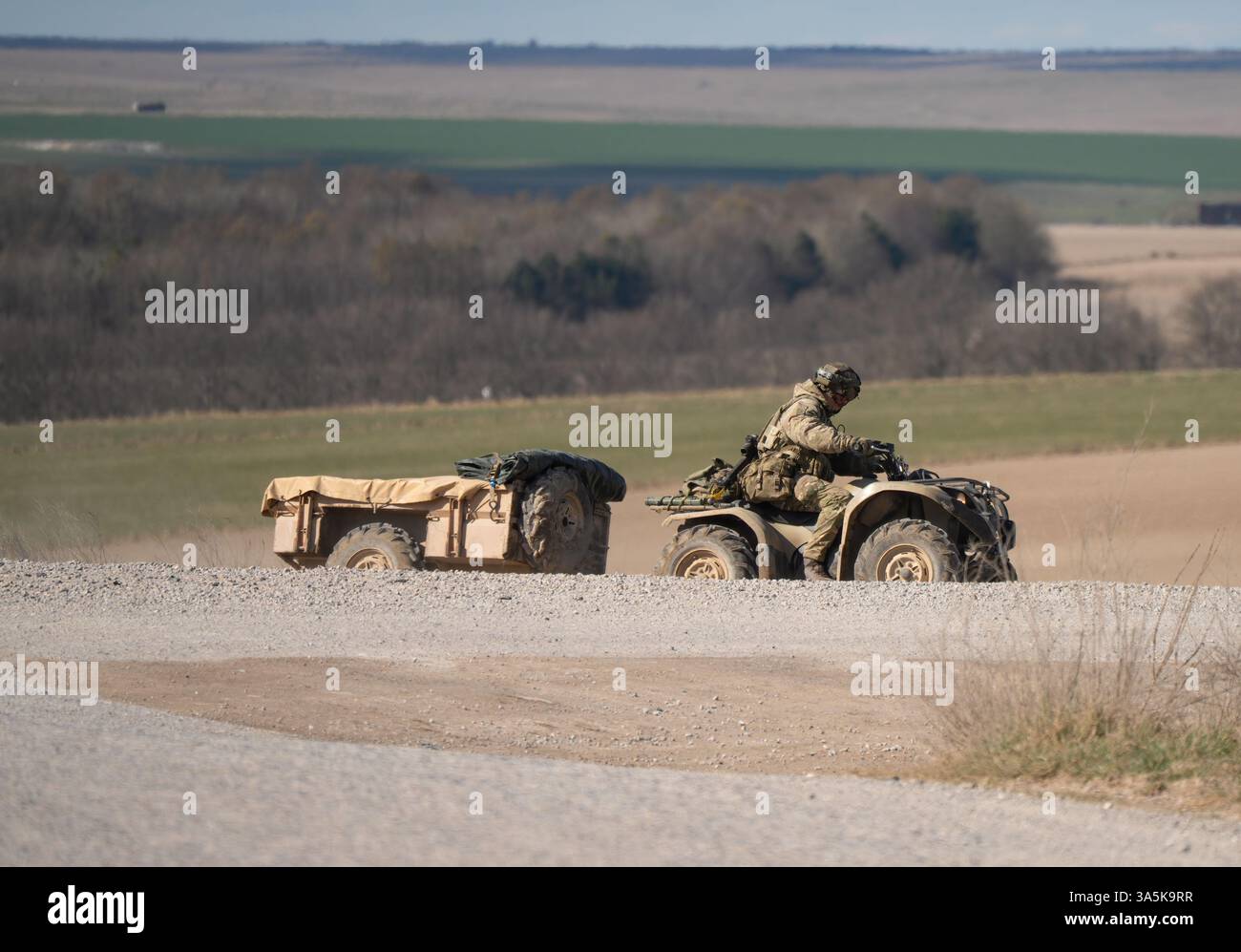 British army soldier driving an all-terrain quad bike with trailer ...