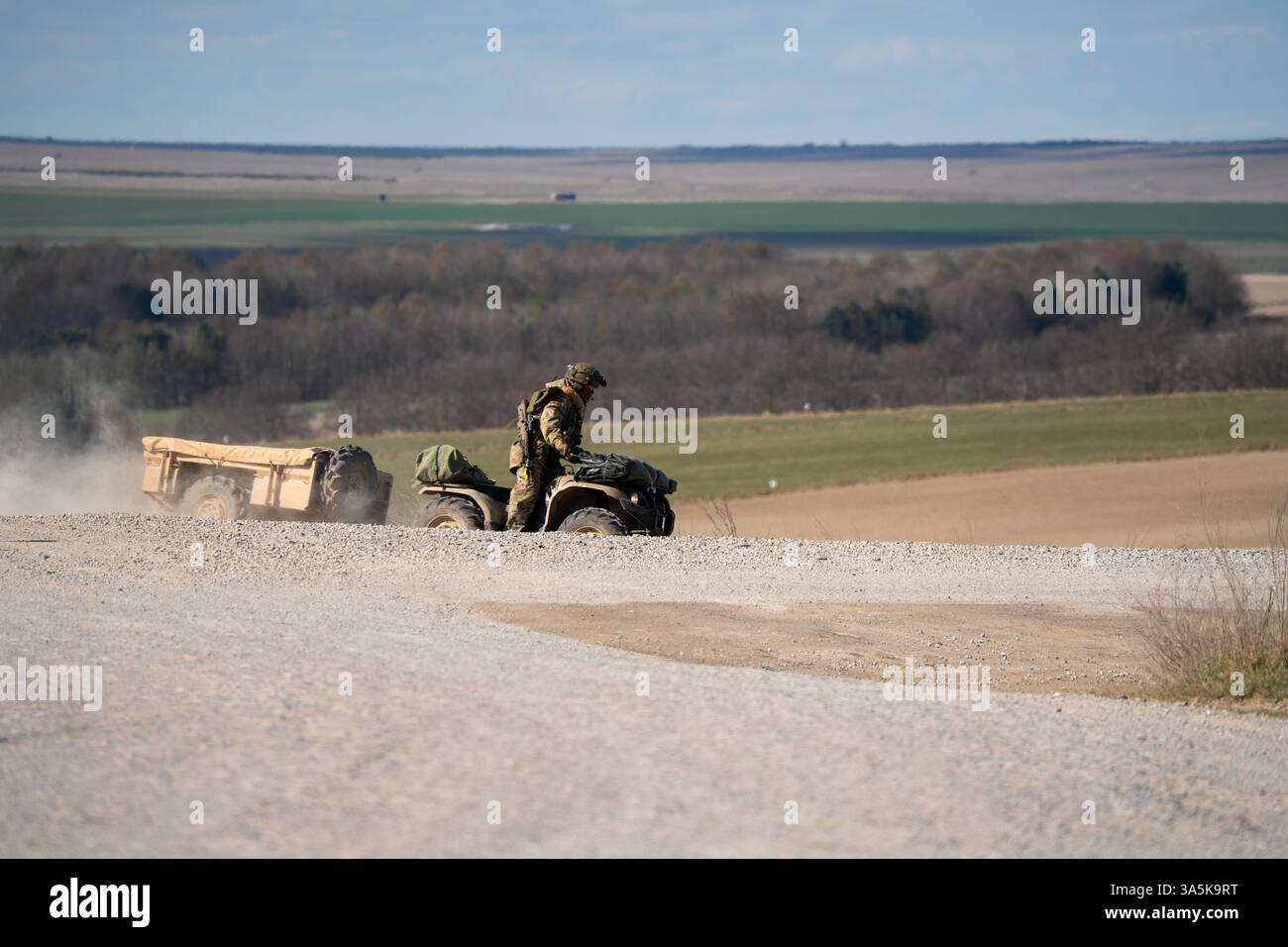 British army soldier driving an all-terrain quad bike with trailer ...