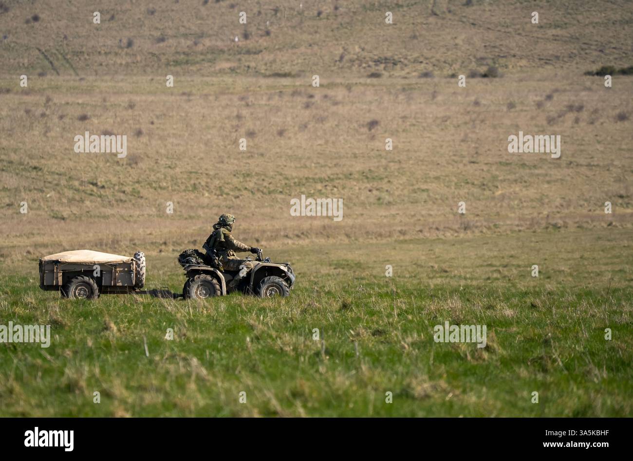British army soldier driving an all-terrain quad bike with trailer ...