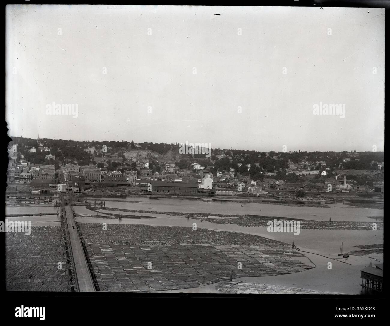 A log boom passes through Stillwater, Minnesota, on the St. Croix River ...