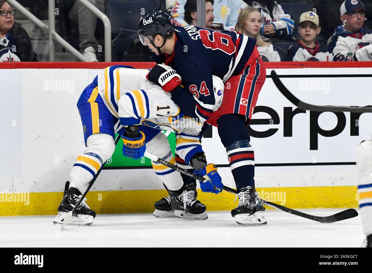 Buffalo Sabres' Jason Zucker (17) is checked by Winnipeg Jets' Logan ...