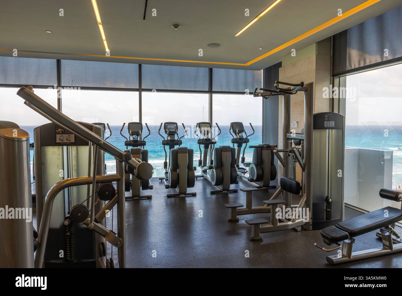 Modern fitness gym with training equipment and panoramic windows ...