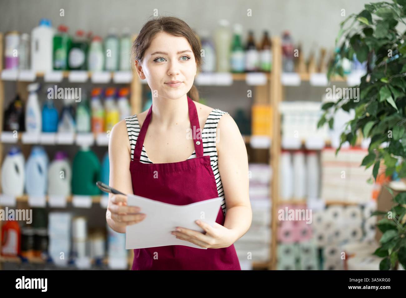 Youmg female seller makes notes on paper - keeps track of the receipt ...