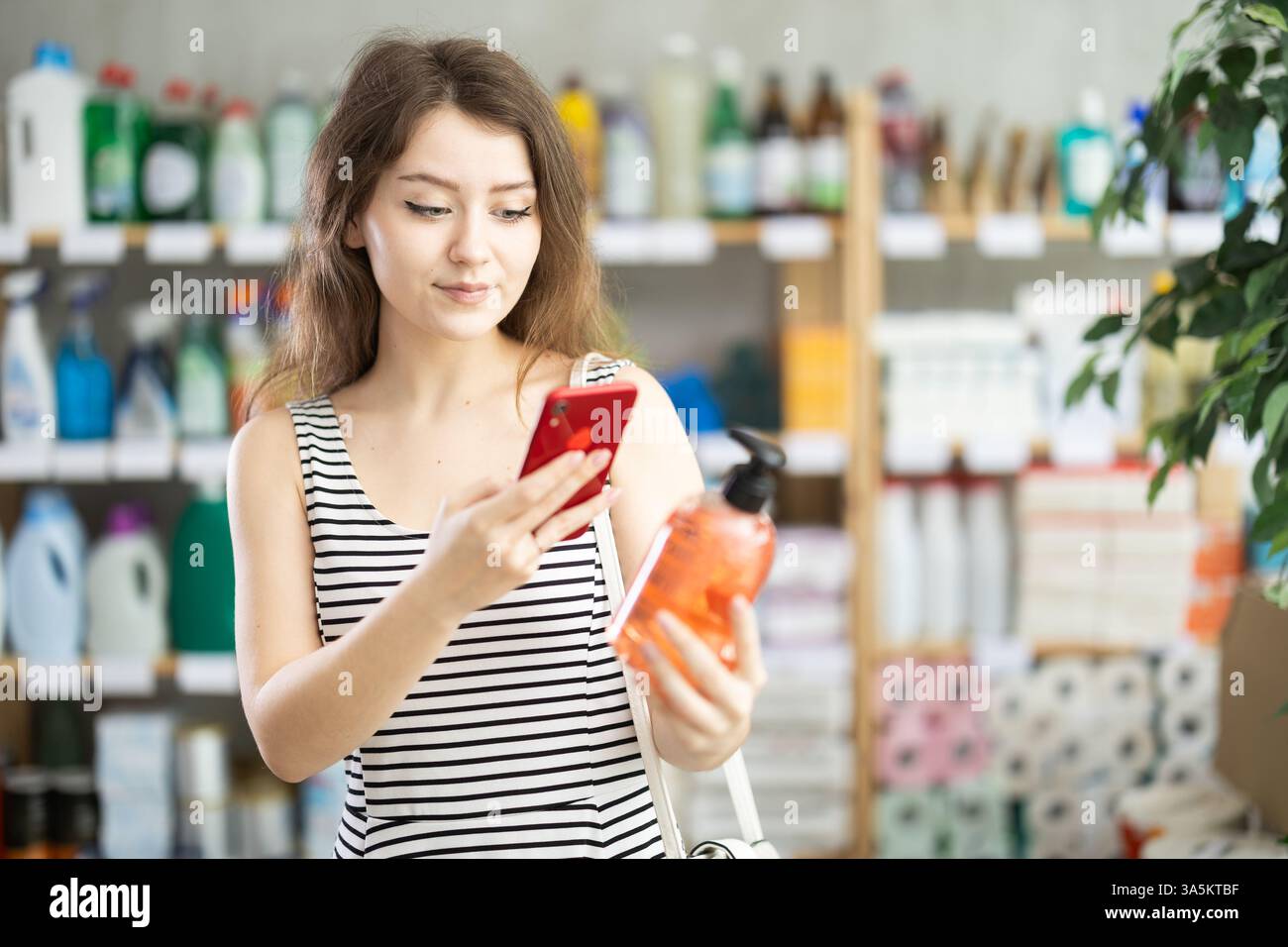 Girl buyer scans qr code on liquid hand soap label Stock Photo - Alamy