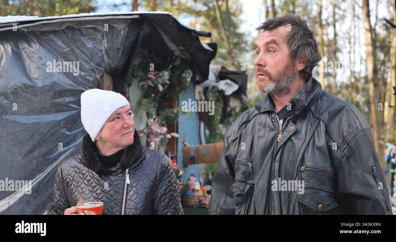 Couple sharing moment near plastic sheet shelter, embodying survival ...