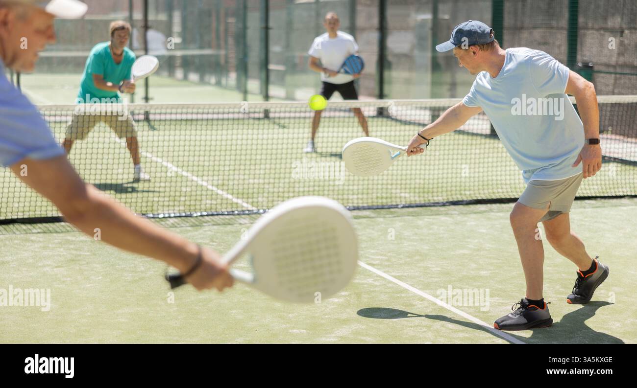 Four men practice playing padel on an outdoor court Stock Photo - Alamy