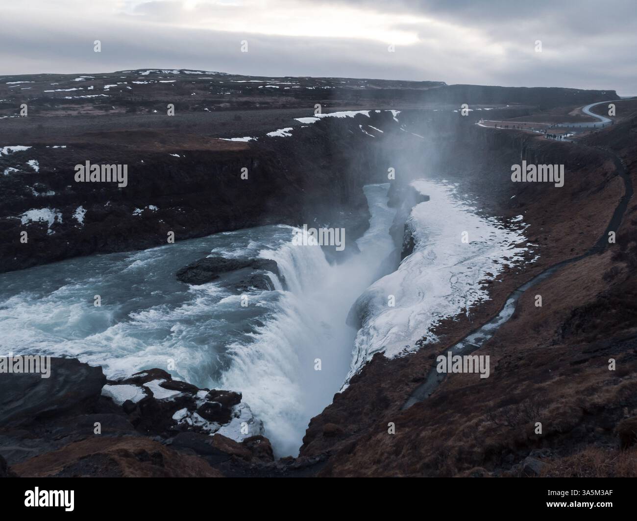 Gullfoss waterfall in Iceland, with mist rising over the icy canyon ...