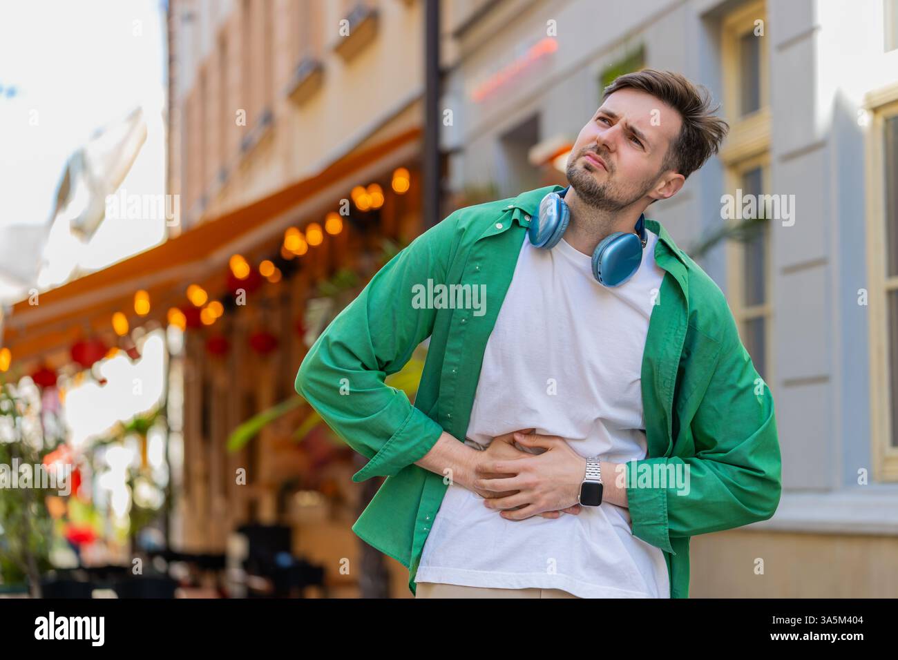 Caucasian young man traveler feeling sudden strong abdominal stomach ...