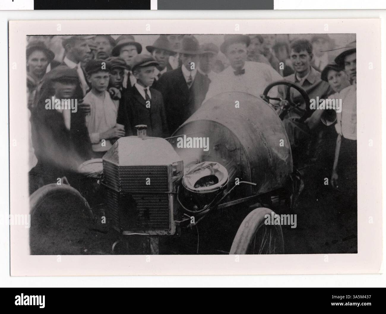 A view of Glenn Allyn's race car crashed into a fence, surrounded by ...