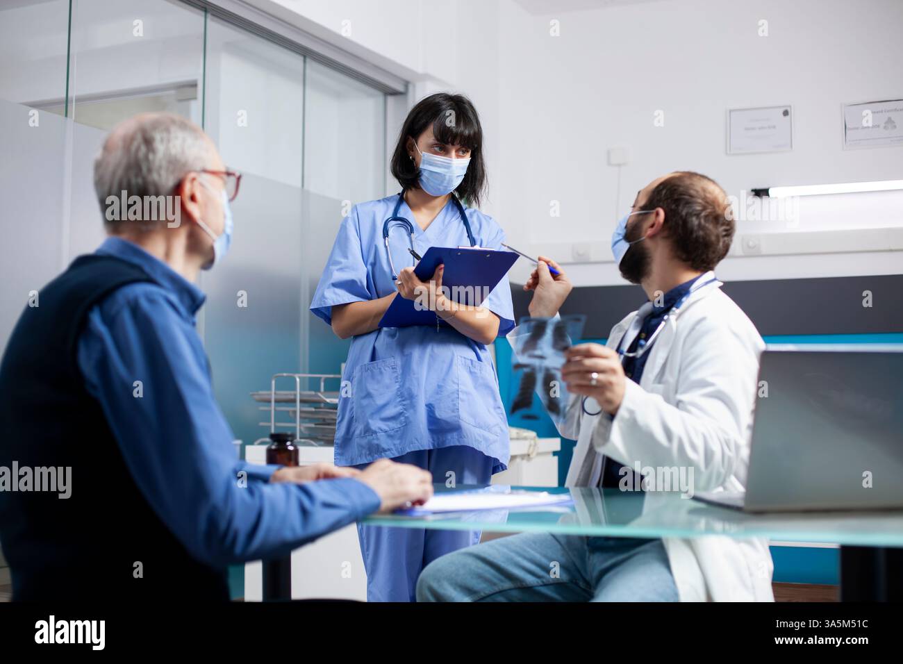 Old man sitting in clinic and listening to young healthcare workers ...