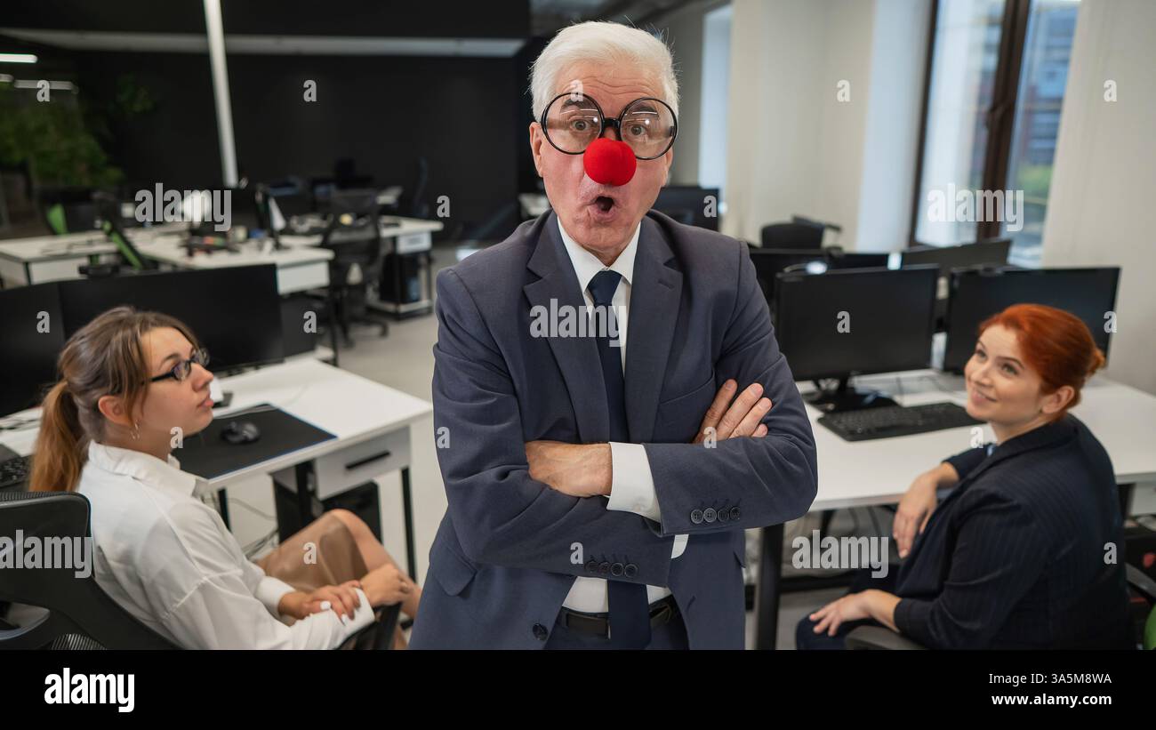 An elderly man in a clown costume fools around at work Stock Photo - Alamy