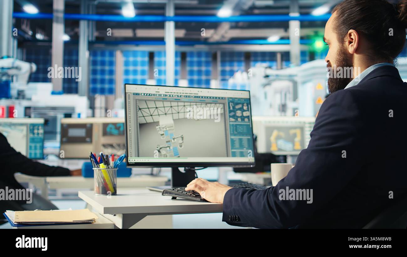 Man in photovoltaics factory monitoring system performance on PC screen. Solar panels ...
