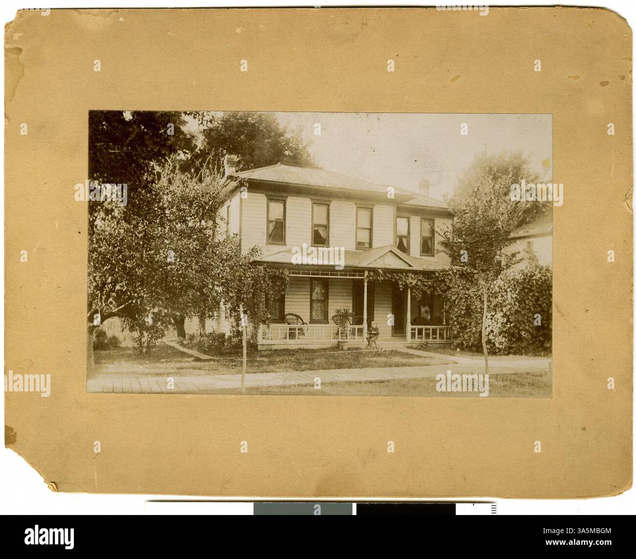 Exterior view of the Adolph Rockey home in Mankato, Minnesota, with a boy on a tricycle in front ...