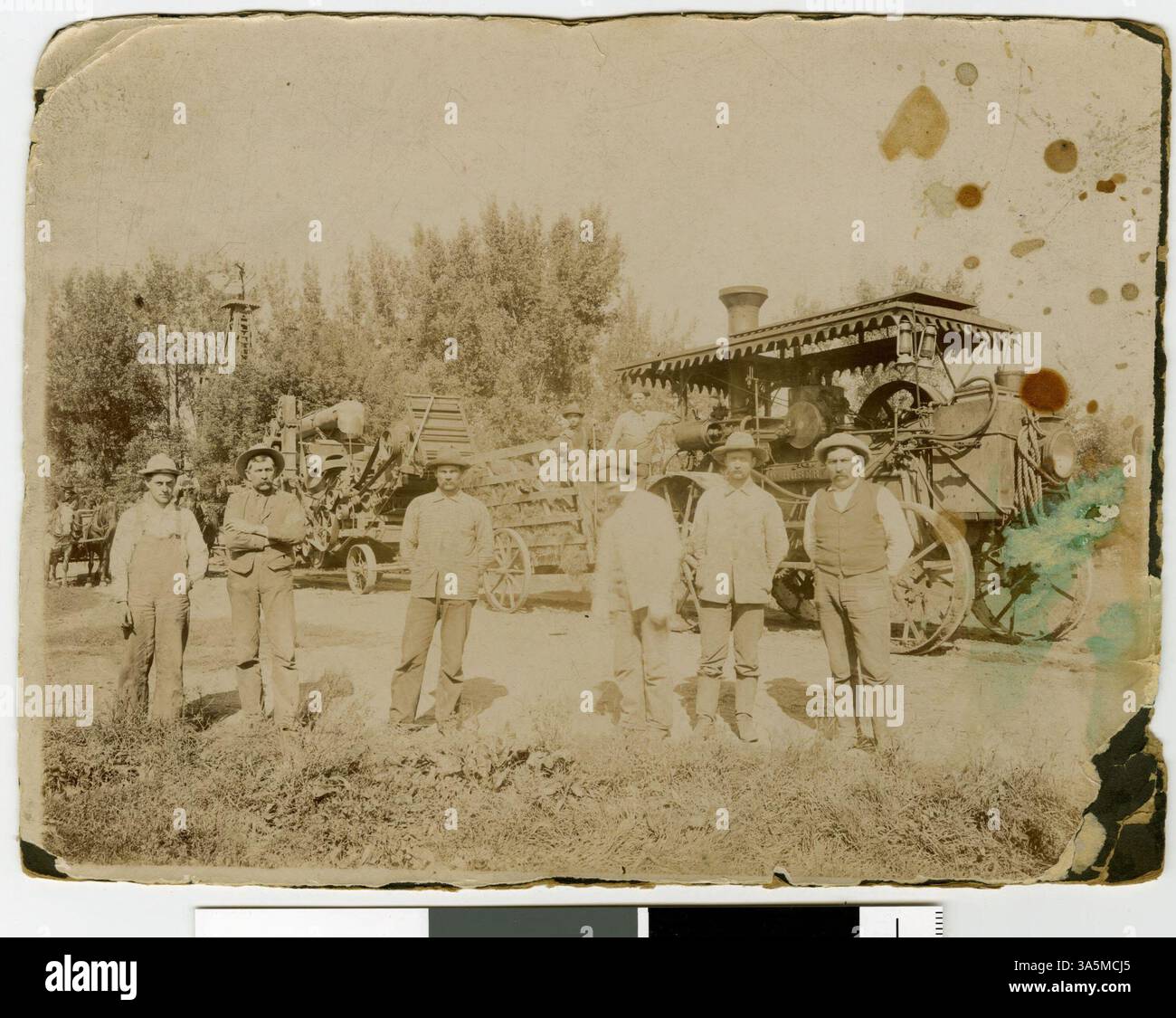 A threshing crew is pictured in the St. Clair area, with seven men and ...