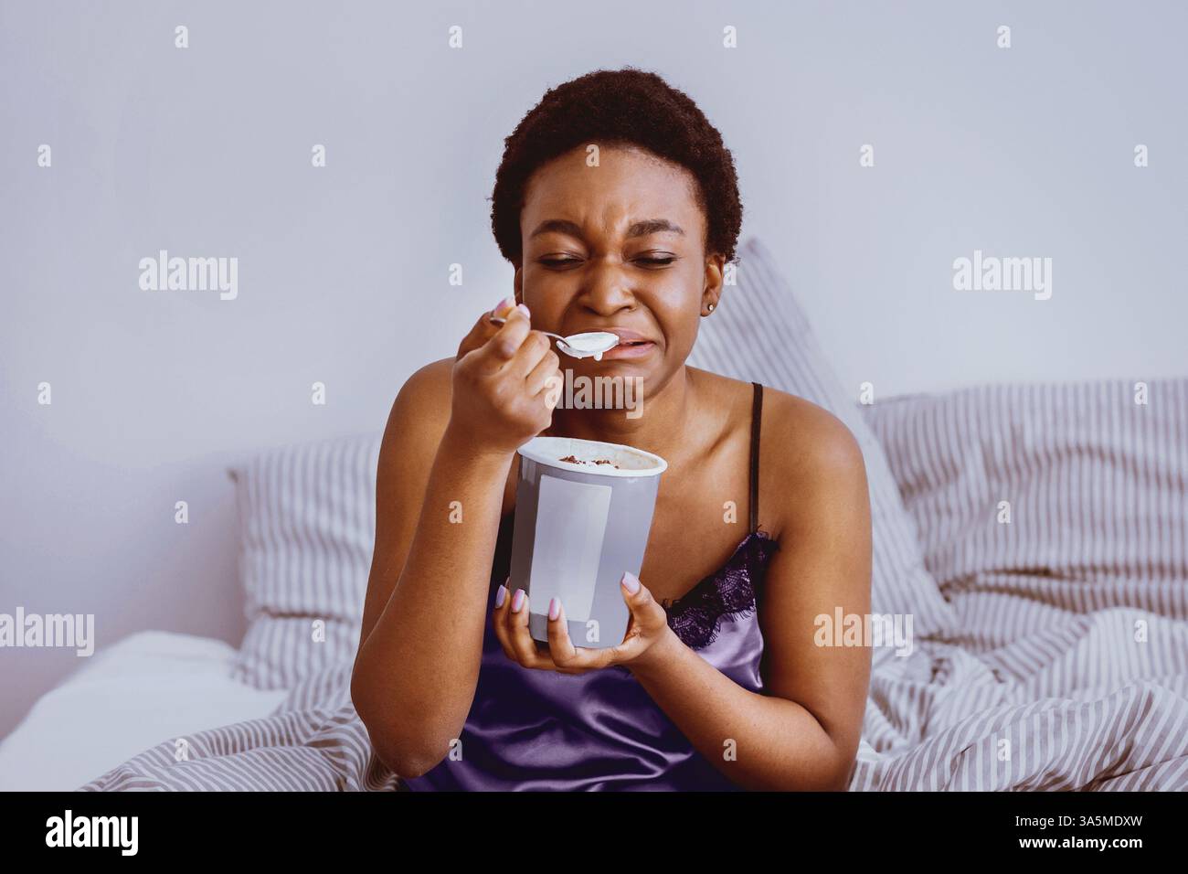 Breakup concept. Crying girl eating ice cream in bed Stock Photo - Alamy