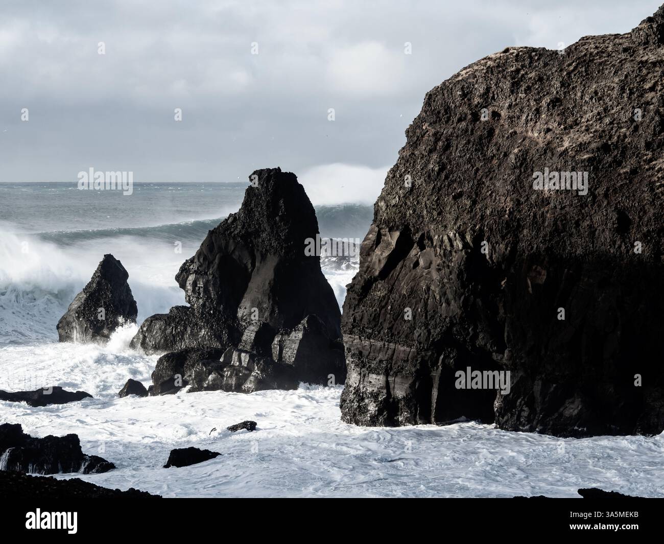 Jagged volcanic rocks rise from the turbulent waters of Valahnúkamöl ...
