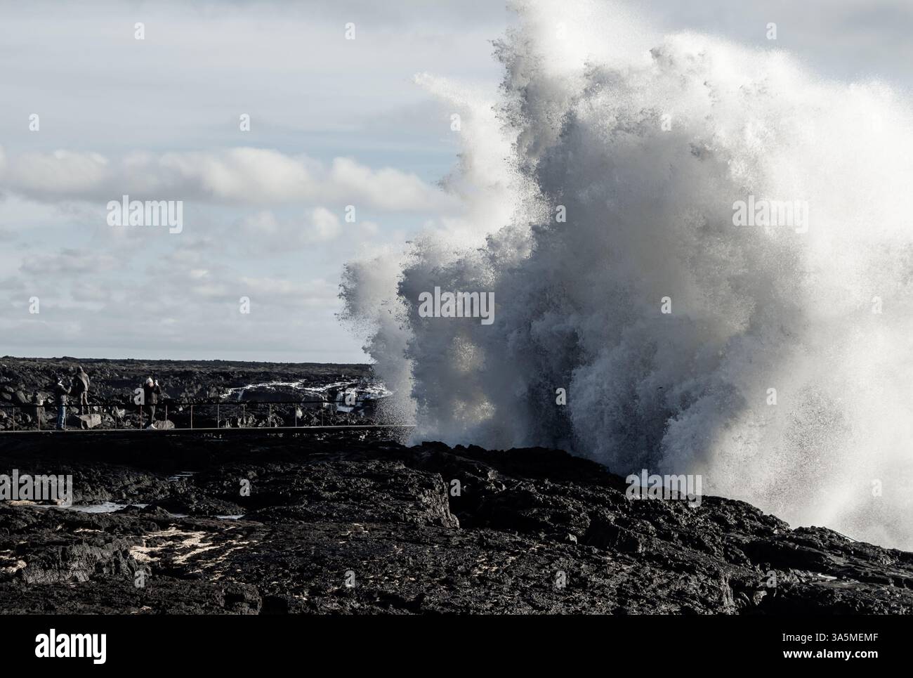 A colossal wave erupts against volcanic rocks in Iceland as onlookers ...