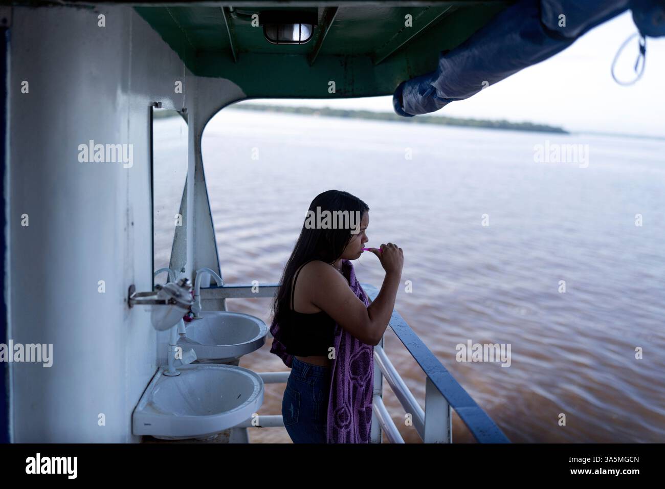A woman brushes her teeth as she nears Belem, Brazil on Sunday, March ...