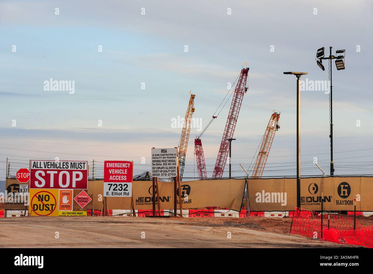 Mesa, Arizona, USA. 23rd Mar, 2025. Cranes rise behind signage at the ...