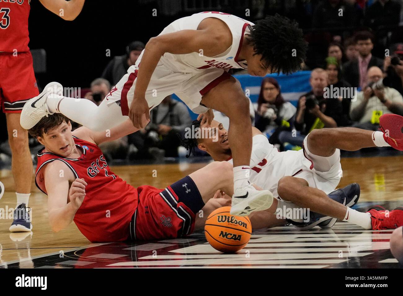 Alabama guard Aden Holloway, center, jumps over Saint Mary's center ...