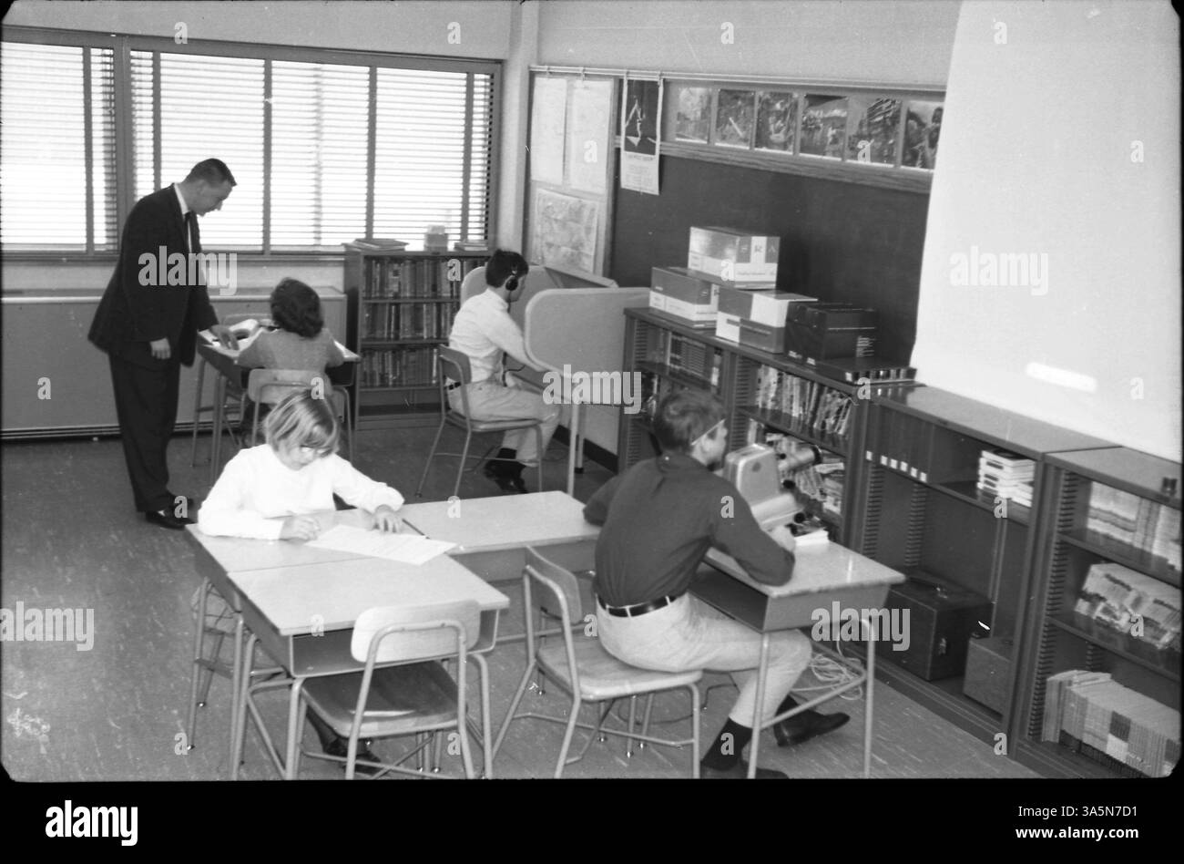 A student projects an image onto a screen during a 1965 educational ...
