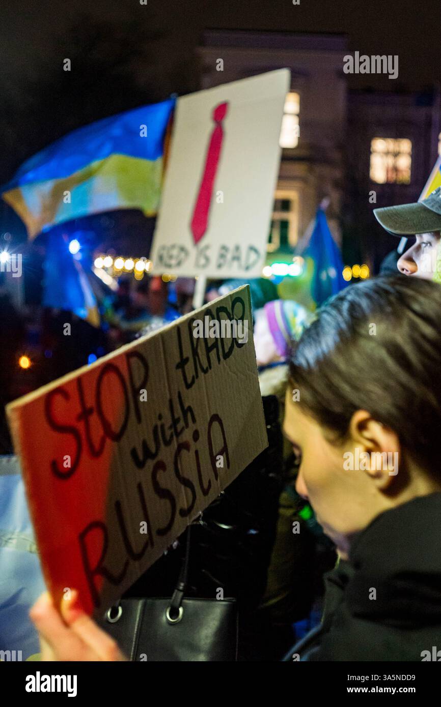 In front of a large placard with a drawing of President Donald Trump's ...