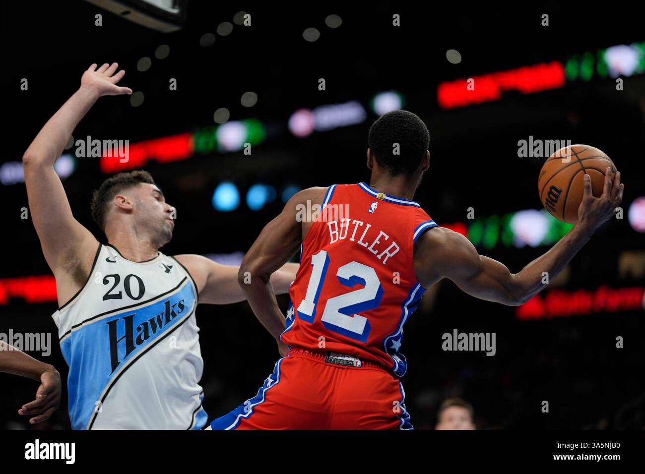 Philadelphia 76ers guard Jared Butler (12) grabs a rebound near Atlanta Hawks forward Georges ...