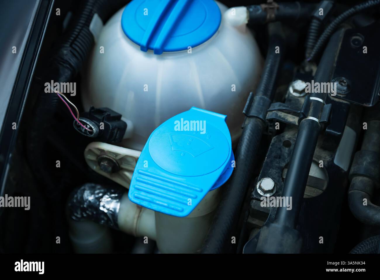 Windshield washer and coolant reservoirs in engine compartment, closeup ...
