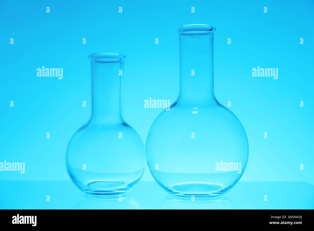Empty flasks on light blue background. Laboratory equipment Stock Photo ...