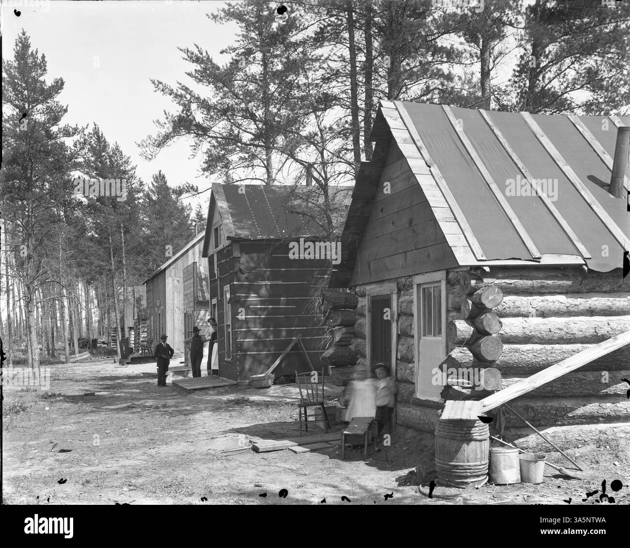 The first buildings in Cass Lake are surrounded by pine forest, with a ...