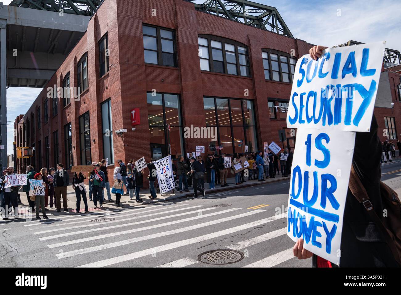 Mar 22, 2025; Brooklyn, NY, USA; Protestors gather outside a Tesla ...