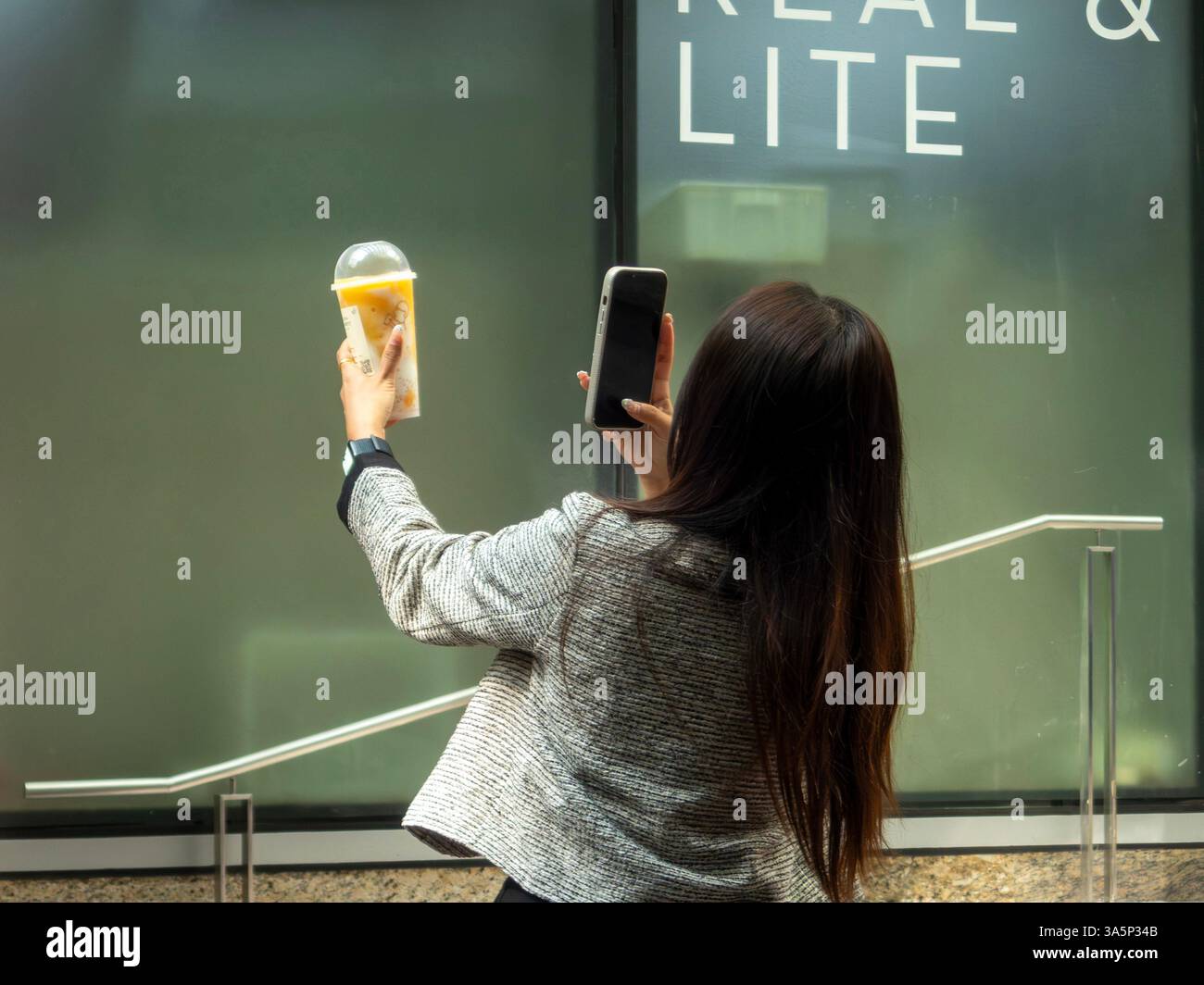 Hong Kong, China. 23rd Mar, 2025. A woman takes a photo of their drink in front of the HEYTEA ...