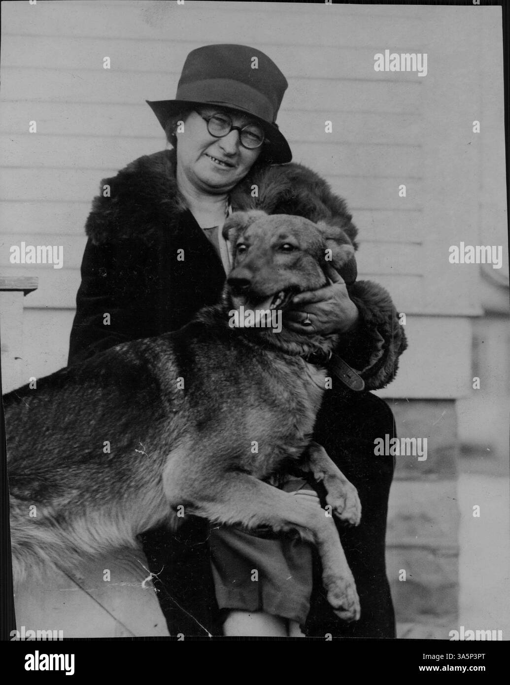 This photo features Mrs. Vider Niles with her dog, Mitzi, offering a ...